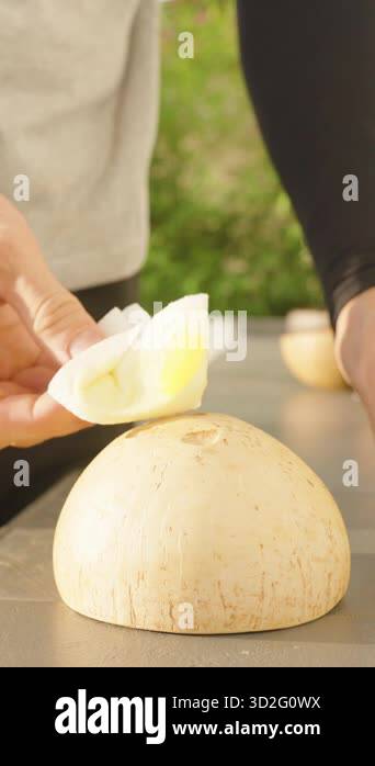 Vertical video. Hands Polishing Outer Surface of Coconut Shell Bowl ...
