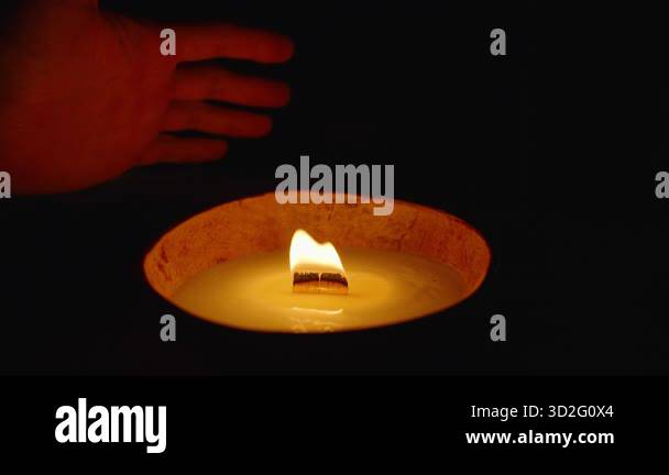 Hand Near Burning Wooden Wick Candle in Coconut Shell, low light ...
