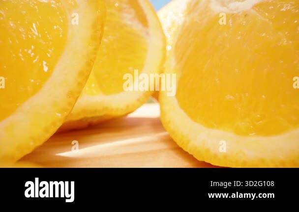 Close Up of Fresh Orange Wedges on Wooden Surface with Bright Sunlight ...