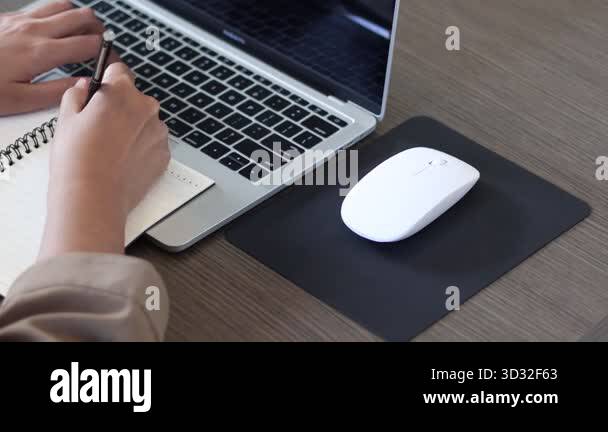 Closeup top view of a simulated pose person typing on the keyboard on a ...