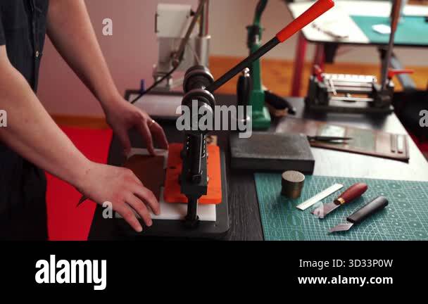 Craftsman uses press machine to imprint patterns into leather 4k video ...