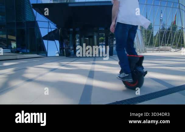 Rear view of a man on an electric monowheel entering a futuristic ...