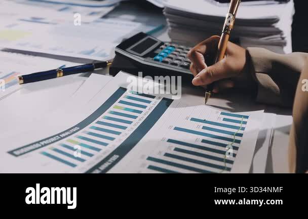 businessman using calculator to calculate financial statistics on table ...
