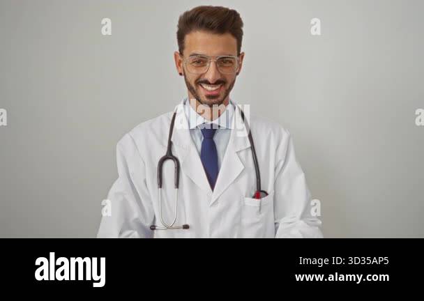 Young hispanic man in doctors coat gesturing ok sign with both hands ...
