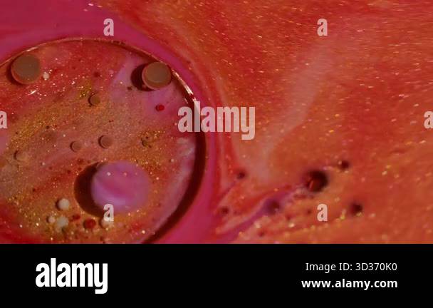 Pour shiny emulsion. Ink splash. Defocused orange pink color flow ...