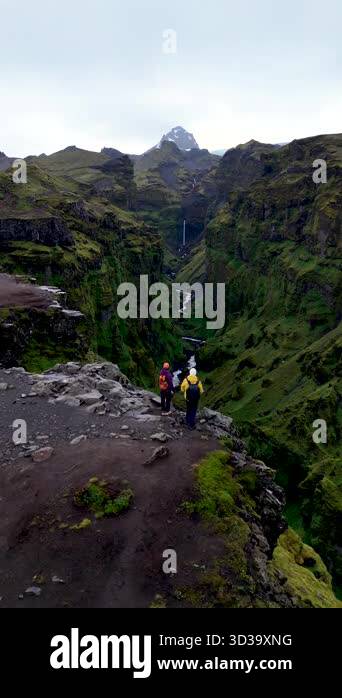 Adventurers stand on the edge of Mulagljufur Canyon in Iceland ...