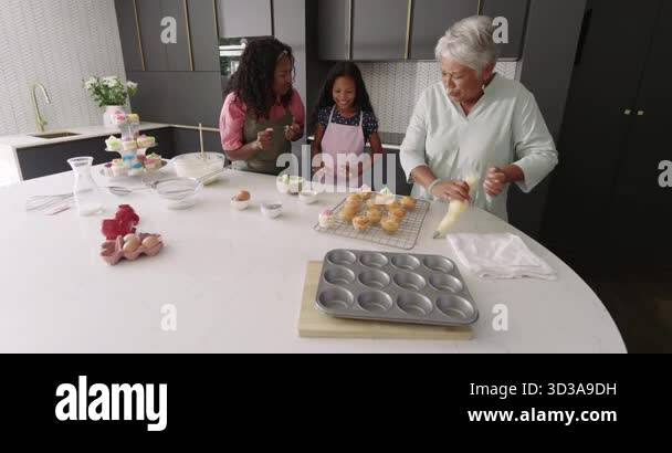 Baking cupcakes, three generations sharing laughter and joy in modern ...