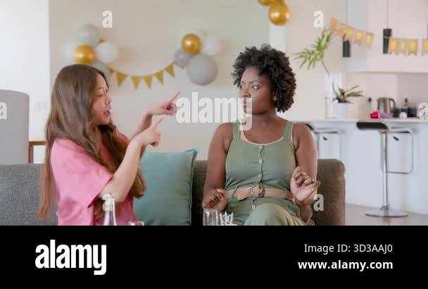 Diverse friends cleaning living room after celebration, holding plate ...