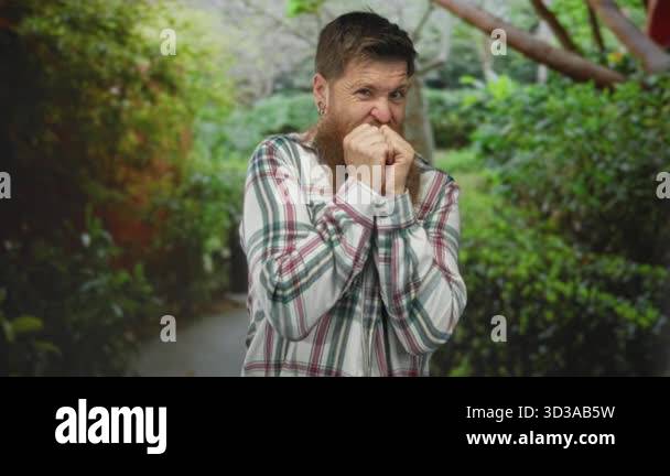 Man with long red beard wearing plaid shirt holds hands forward while ...