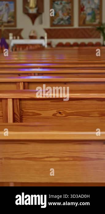 Interior view of a church featuring empty wooden pews leading to an ...