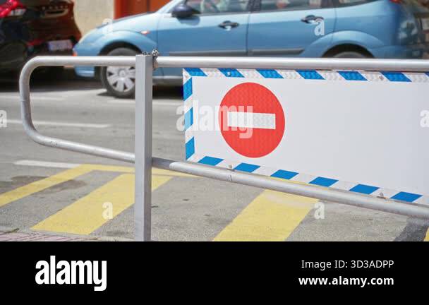 Traffic sign with a red and white no entry symbol stands beside a busy ...