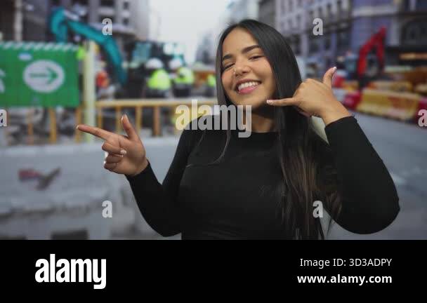 Woman hand calling gesture at a construction site with a latin hispanic ...