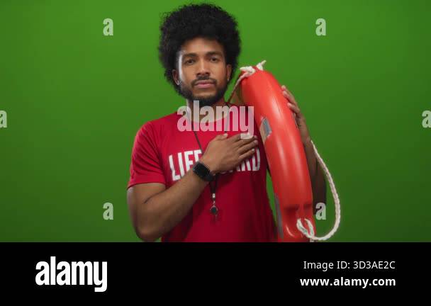 Lifeguard man in red shirt holds life preserver with oath gesture ...