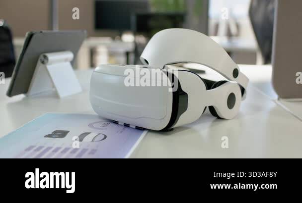 Camera focusing on white VR headset on office desk, revealing walking ...