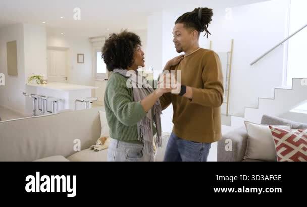 Couple clasping hands and dancing in modern living area, spinning under ...