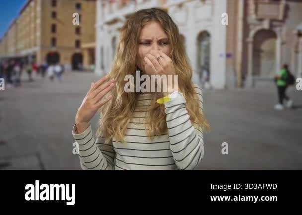 Woman gestures with hands in disgust while standing in a city square ...