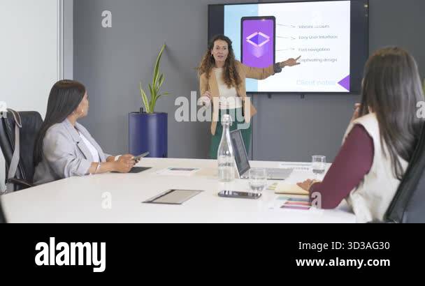 Entering conference room demonstrating app on monitor, woman presenter ...