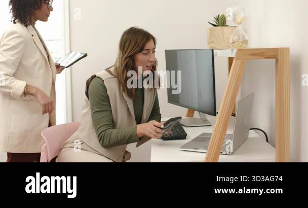 Diverse female coworkers reacting to tablet tap, adjusting laptop ...