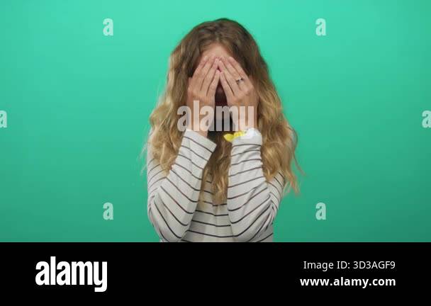 Woman face covering pose in studio uses blonde, young model against ...