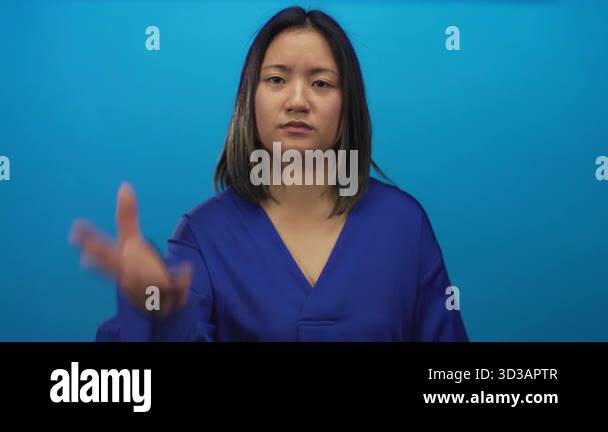 Woman showing determination with clenched fist against solid blue ...