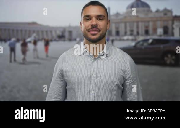 Man smiles and makes ok sign with hand in building square before ...