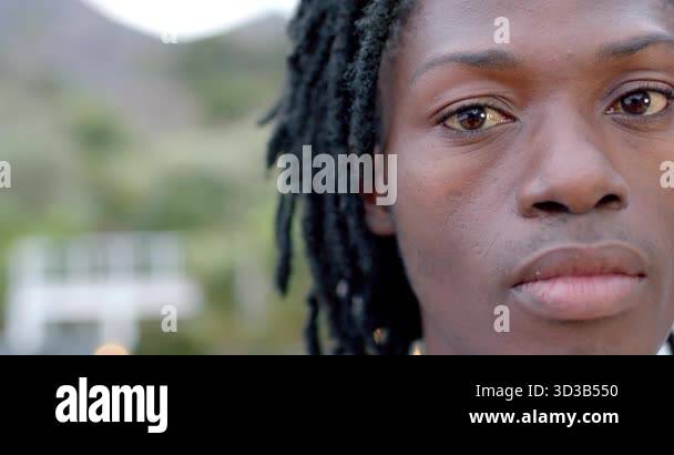 African American man holding gaze on camera, mouth softening into warm ...