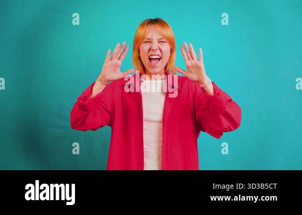 Joyful teenager shouting loudly with an open mouth and raised hands ...