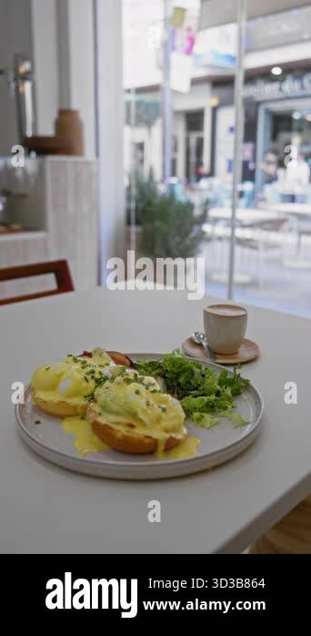 Delicious eggs benedict served on a table in a cozy restaurant with ...