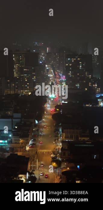 Aerial vertical footage of illuminated cityscape of Miraflores district ...
