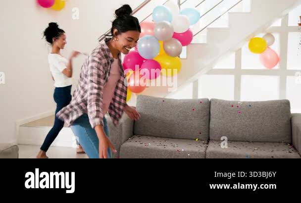 Entering home diverse female friends hanging balloons on steps ...