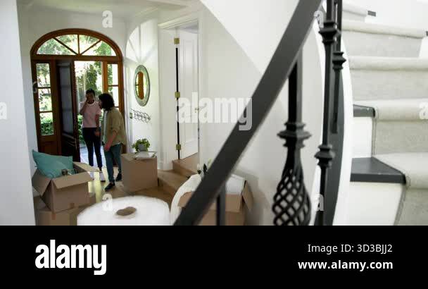 Happy man leading excited partner with covered eyes through door of new ...