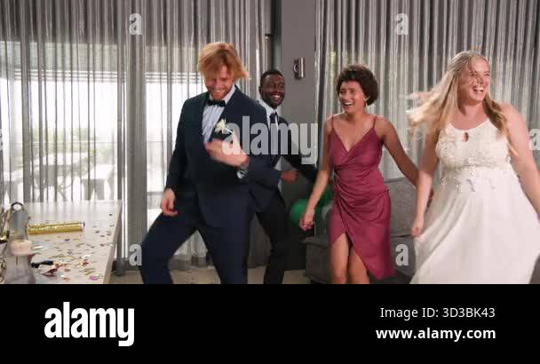 Happy bride and groom and diverse friends dancing at a wedding ...
