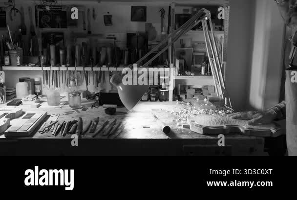Luthier working on top plate of a violin using a gouge, with wood ...