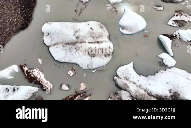 Huge boulders of ice in grey water. Ice melting in Alaska, USA. Aerial ...