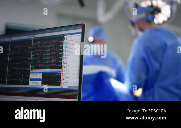 Monitor of medical equipment in the surgical room. Doctors in blue ...