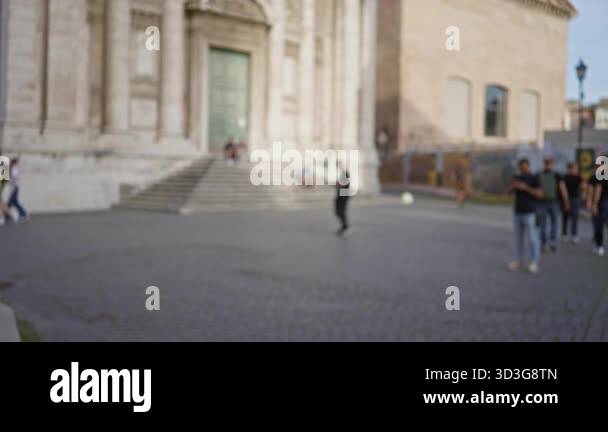 Blurred figures walk past a historic building in the roman forum ...