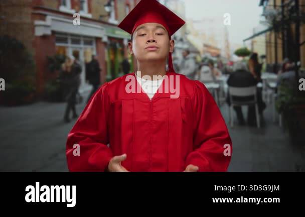 Young chinese man in red graduation gown poses confidently on a lively ...