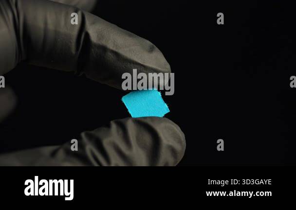 Medical research scientist hand in black gloves holding LSD strip ...