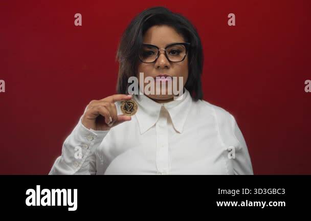 Confident woman holds a tron cryptocurrency coin, gesturing approval ...