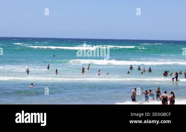 Crowded beach scene with people swimming and relaxing Stock Video ...