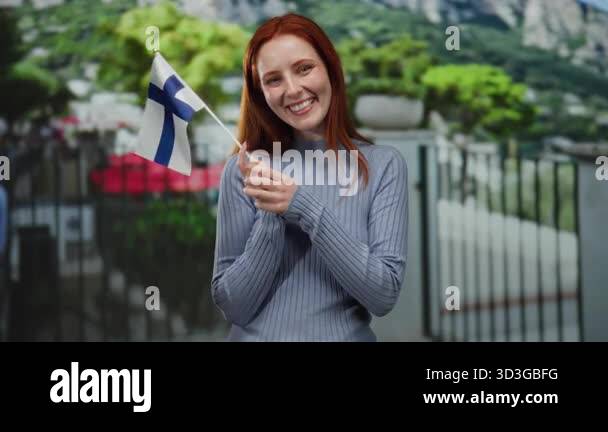Woman smiling holding finland flag outdoors in city street showcasing ...