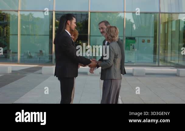 Diverse group of professional colleagues meeting outside a modern ...