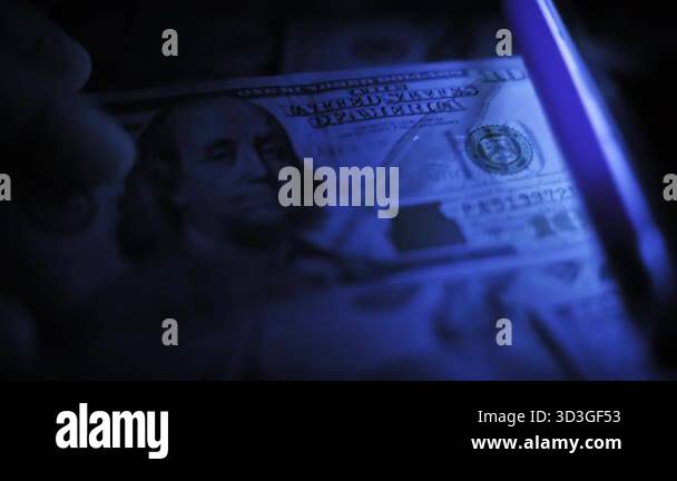 Close shot hand holding a one hundred dollar bill while scanning it ...