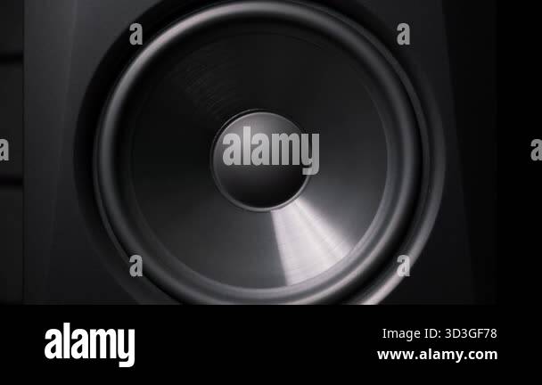 Extreme close-up of a black speaker cone vibrating from intense bass ...