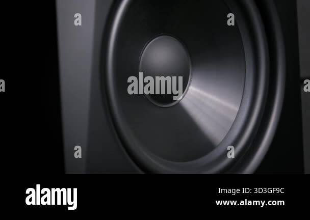 Close-up of a black speaker woofer cone pulsing in slow motion with ...