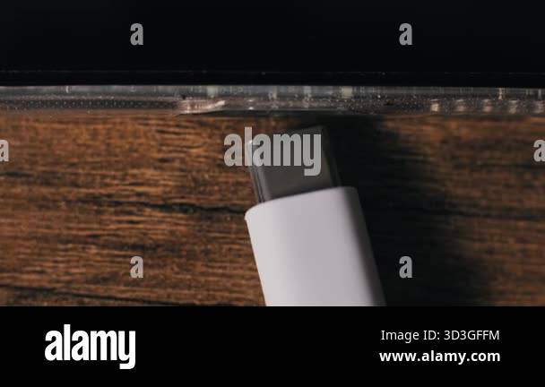 Top-down view USB-C cable plugging into a smartphone port. The device ...