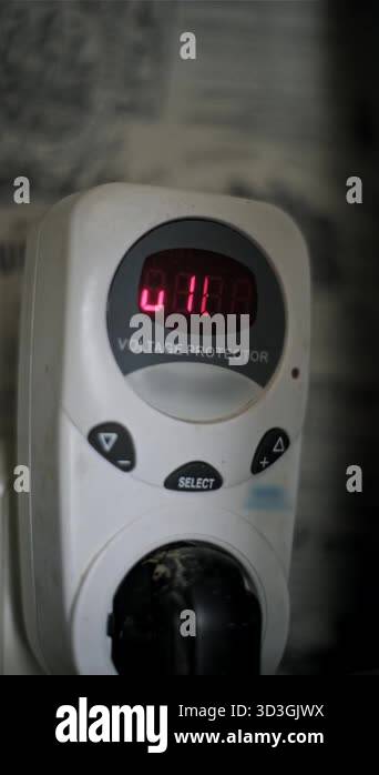 Vertical, a white voltage protector plugged into a wall socket. The red ...