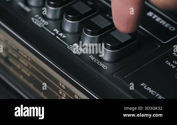 Macro close up shot of a finger pressing the black RECORD button on a ...