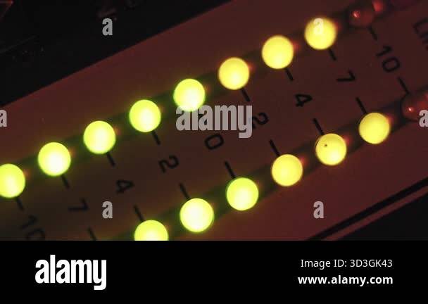 Macro angled of a sound mixer LED level indicator pulsing. Yellow ...