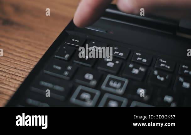 Closeup of a male finger pressing the ESC escape key on a black laptop ...